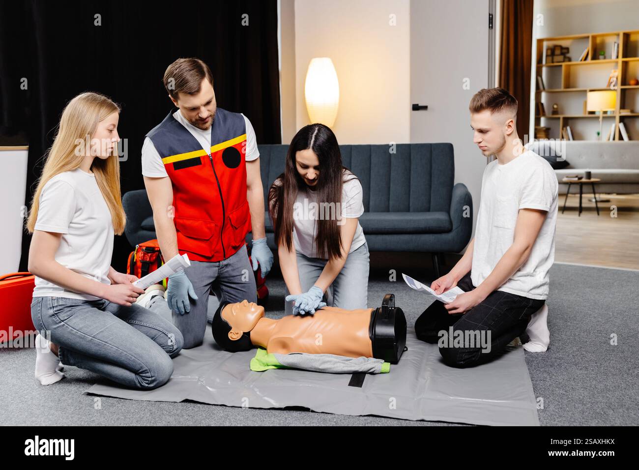 Group of people learning how to make first aid heart compressions with ...