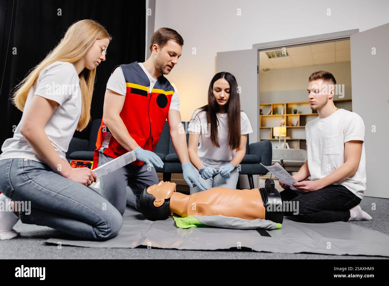 Group of people learning how to make first aid heart compressions with ...