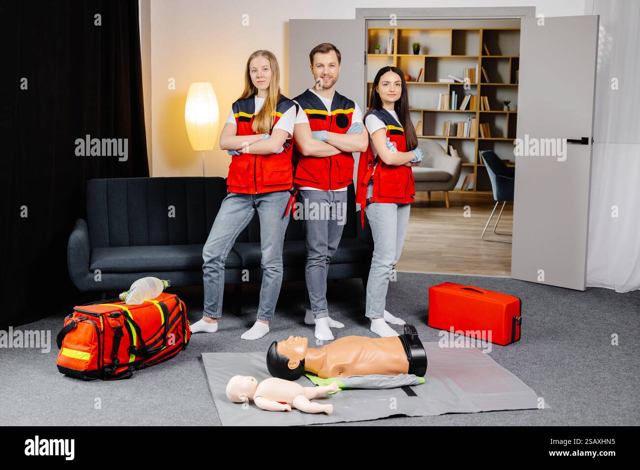 Group of people with cpr dummy looking at camera and smiling after first aid training class ...