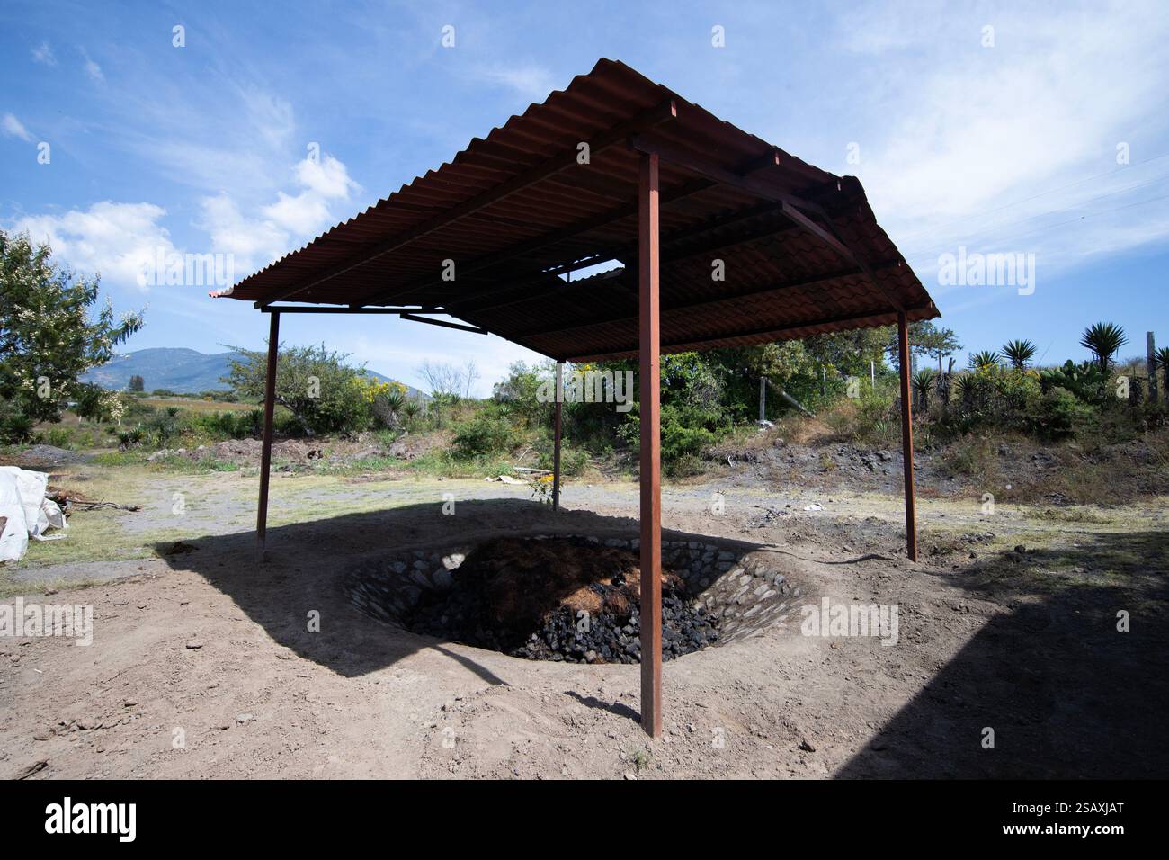 Stone oven in the ground for cooking maguey in an artisanal Mezcal ...