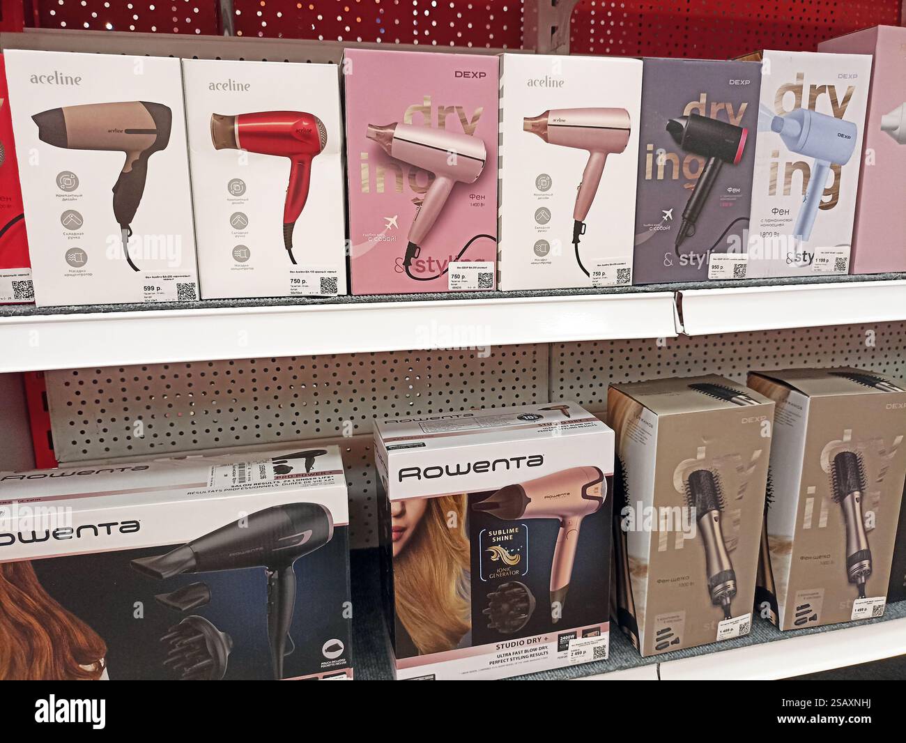 Assorted hair dryers displayed on store shelf with packaging and ...