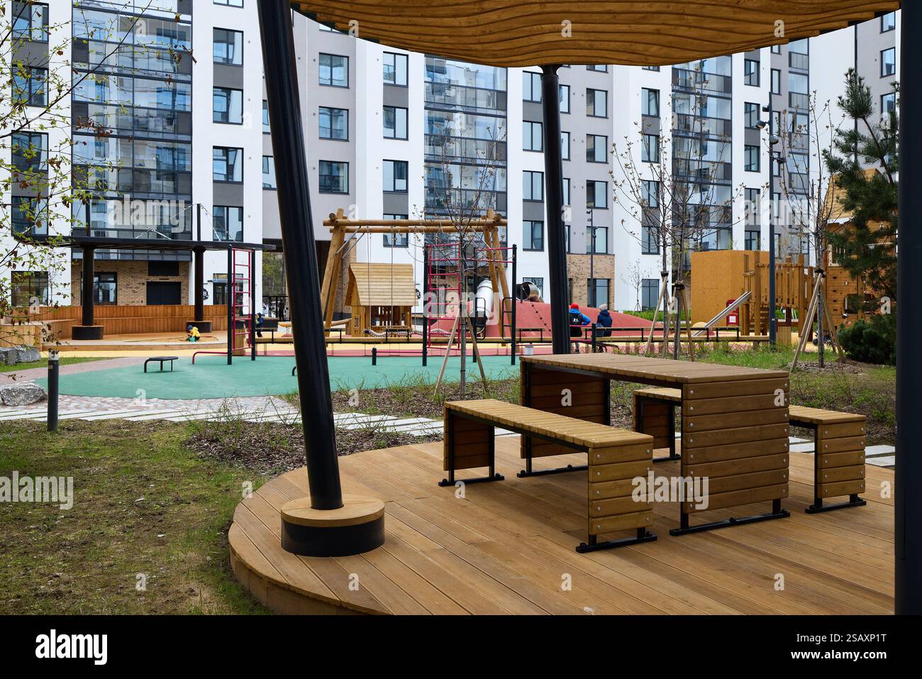 A modern residential playground with seating for community gatherings ...