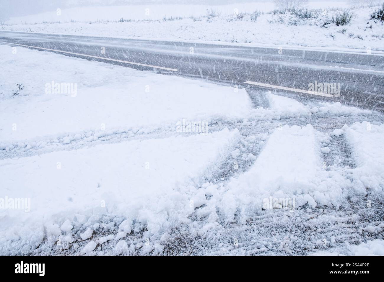 view of a road after a snowfall with tyre marks in the snow, winter ...