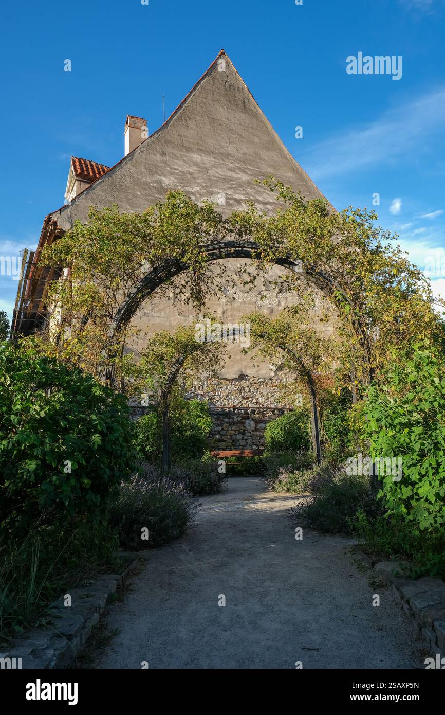 Garden Path with Archway and Rustic Wall Stock Photo - Alamy