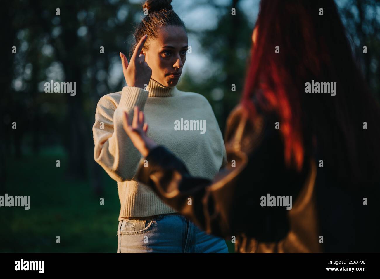 Two women having an intense conversation outdoors during the golden ...