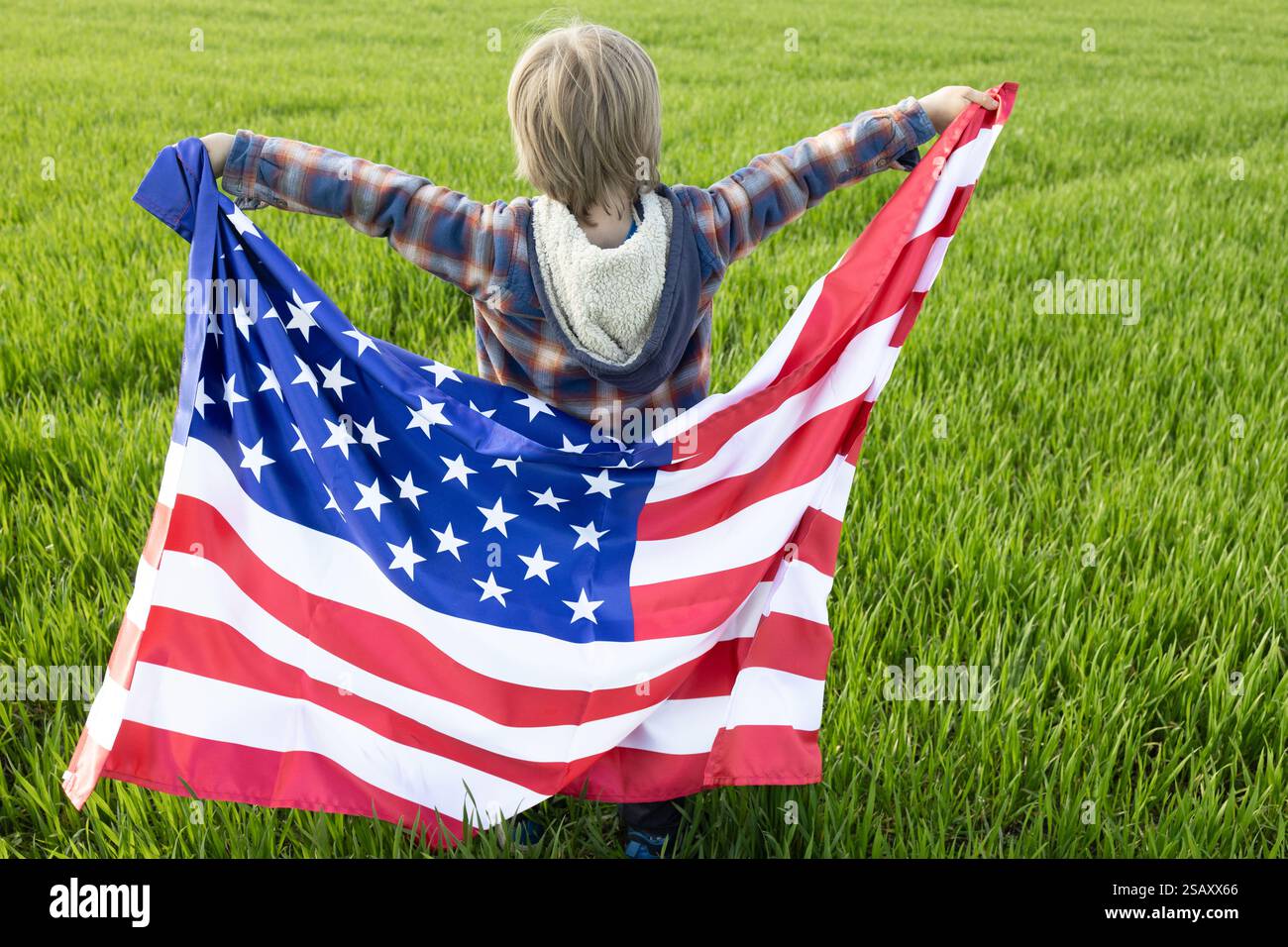 boy proudly holds a large American flag behind his back. Proud to be an ...