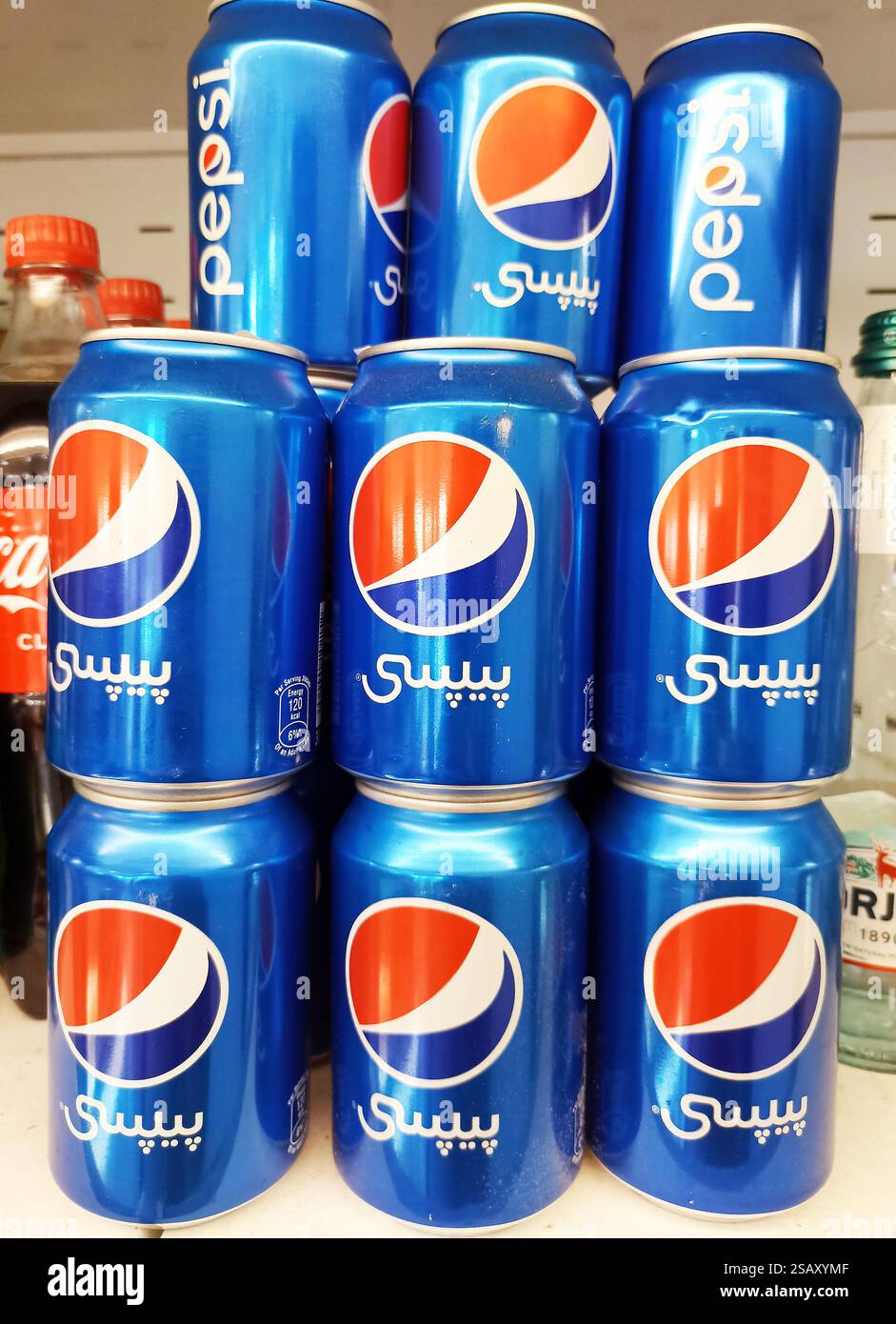 Stacked blue pepsi cans with arabic label displayed in store setting ...