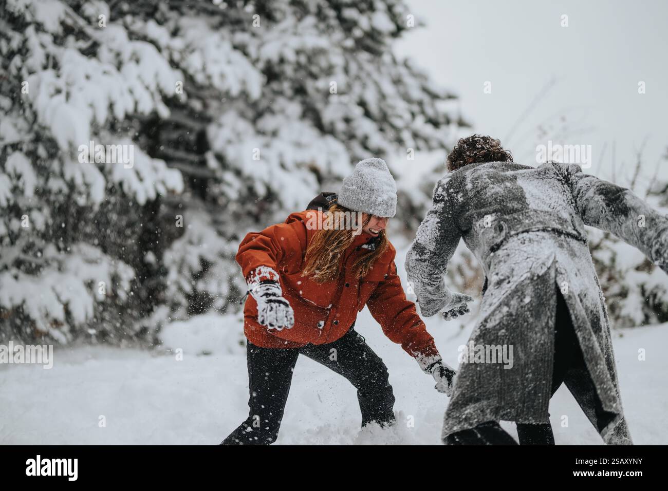 Joyful snowball fight between two friends in a snowy forest Stock Photo ...