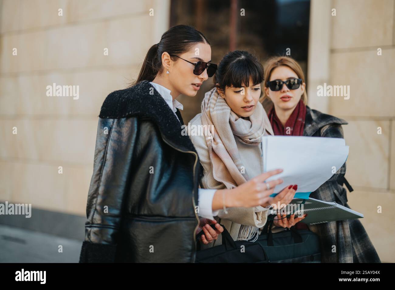 Group of women collaborating on a project plan outdoors Stock Photo - Alamy