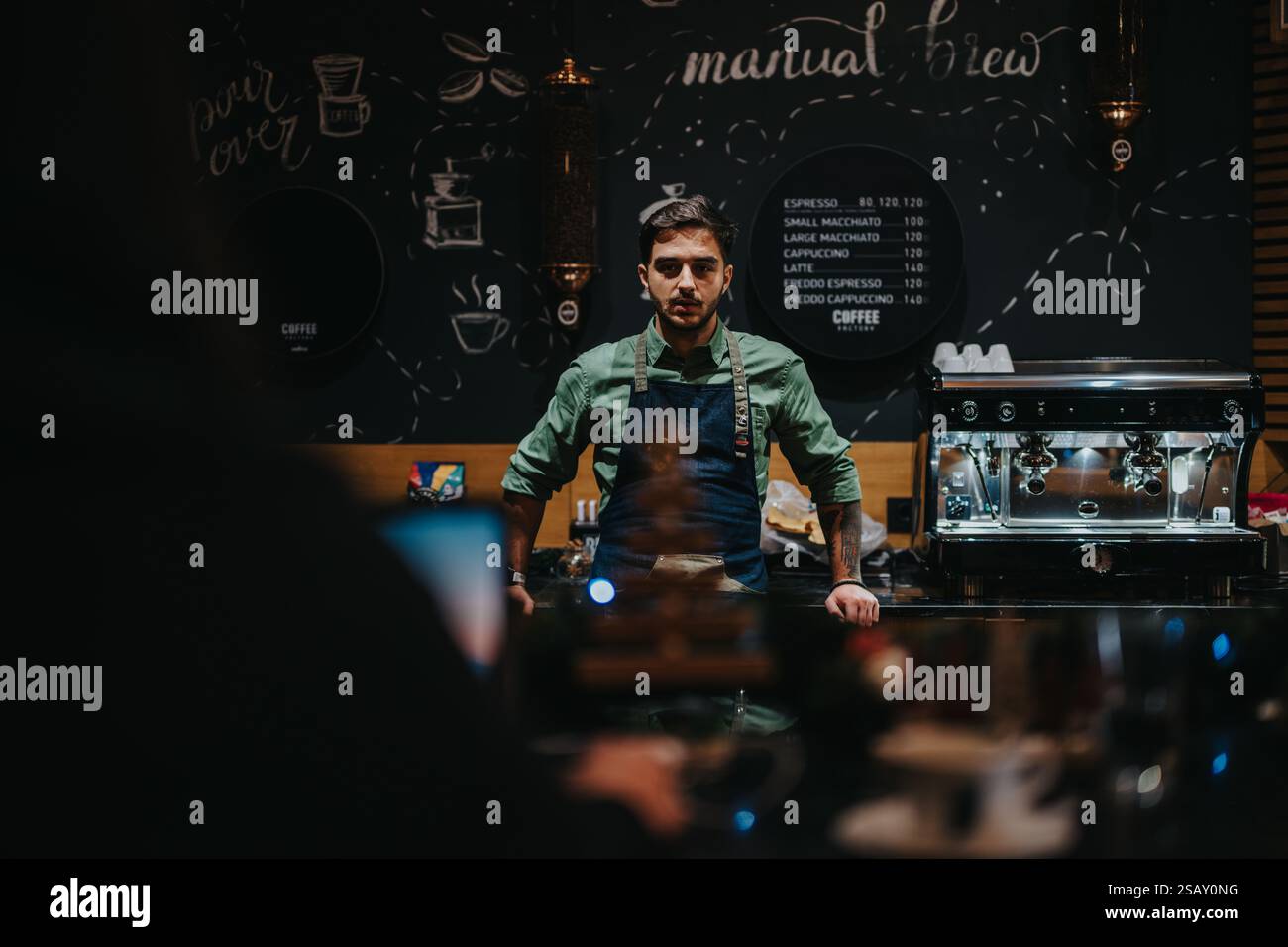 Barista at a coffee shop counter with espresso machine Stock Photo - Alamy