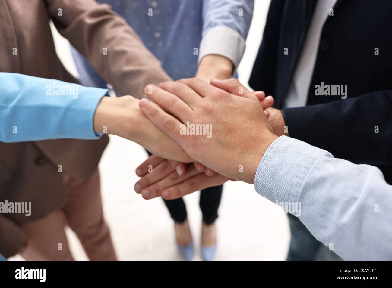 Teamwork. Group of people joining hands together indoors, closeup Stock ...