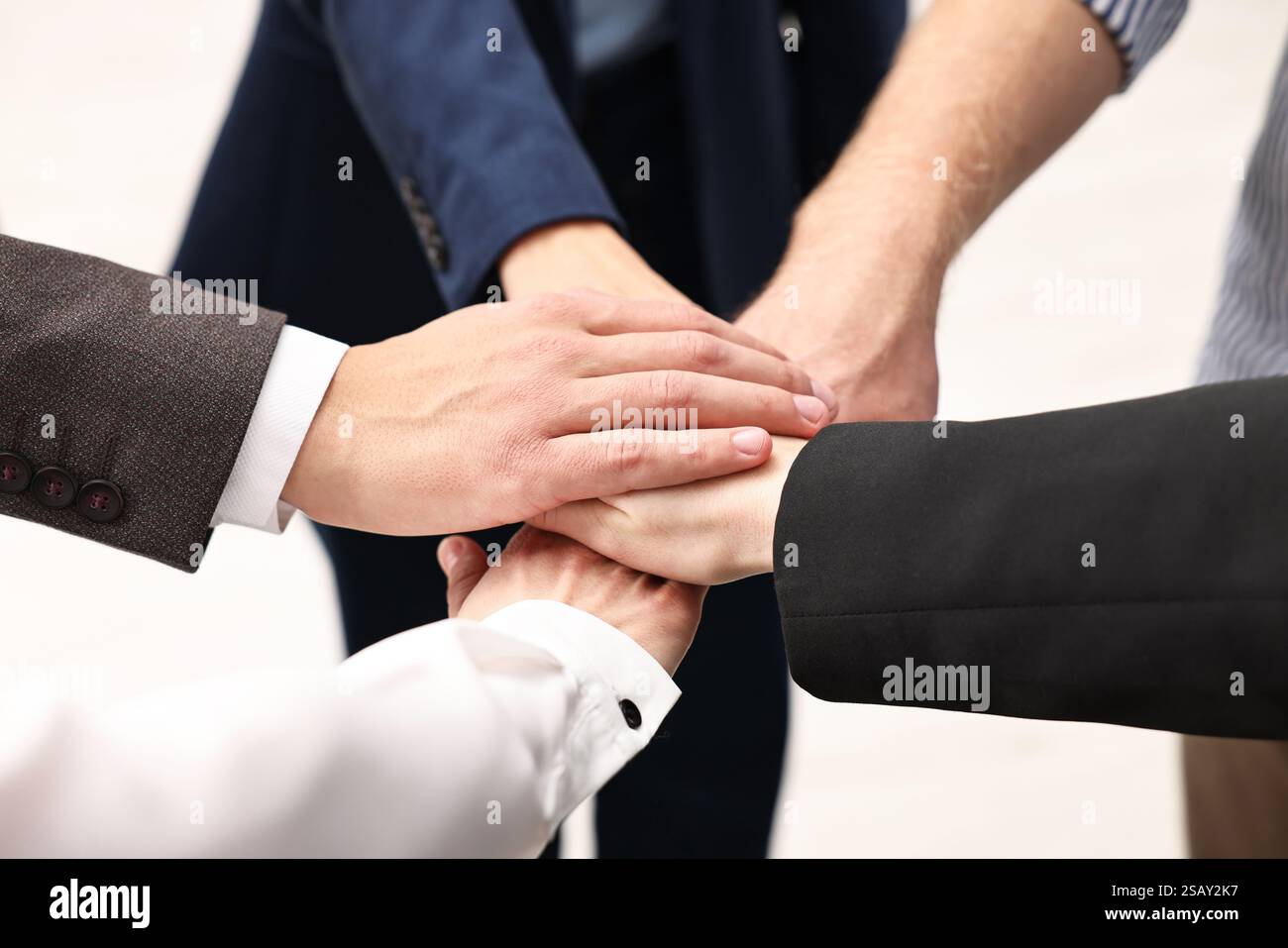 Teamwork. Group of people joining hands together indoors, closeup Stock ...