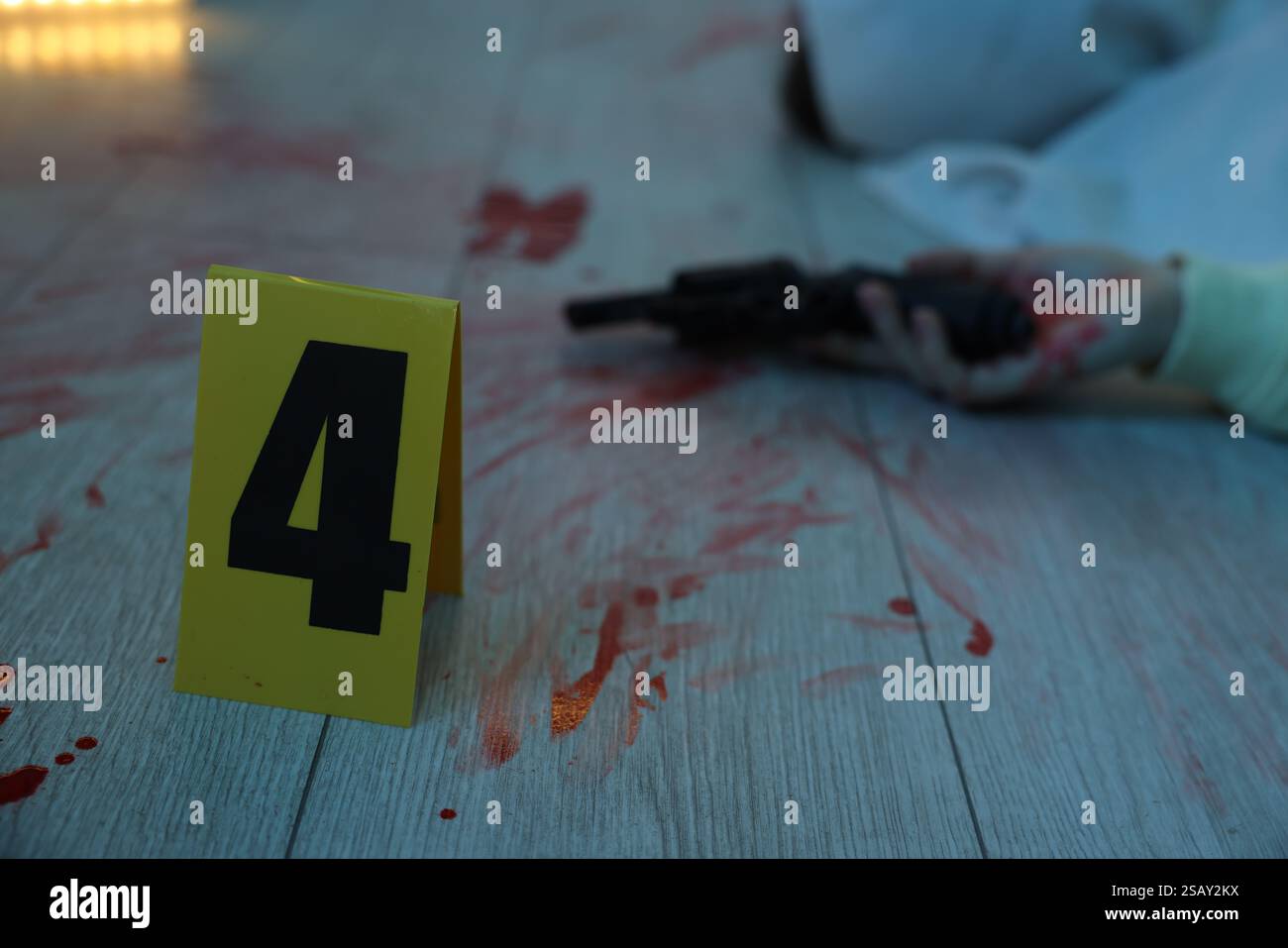 Dead body with gun at crime scene indoors, focus on numbered marker ...