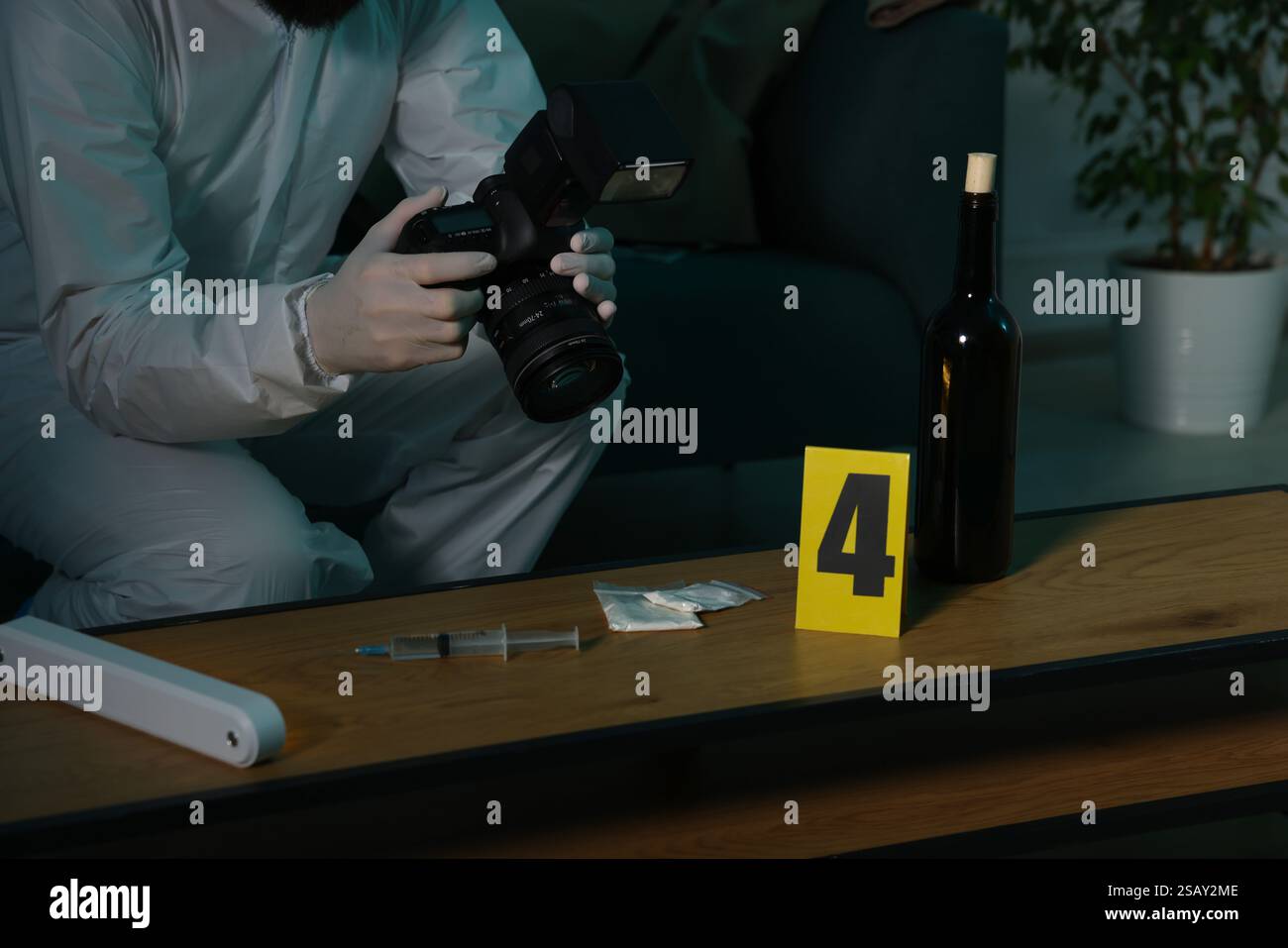 Forensic expert with camera taking photo of evidences at crime scene ...