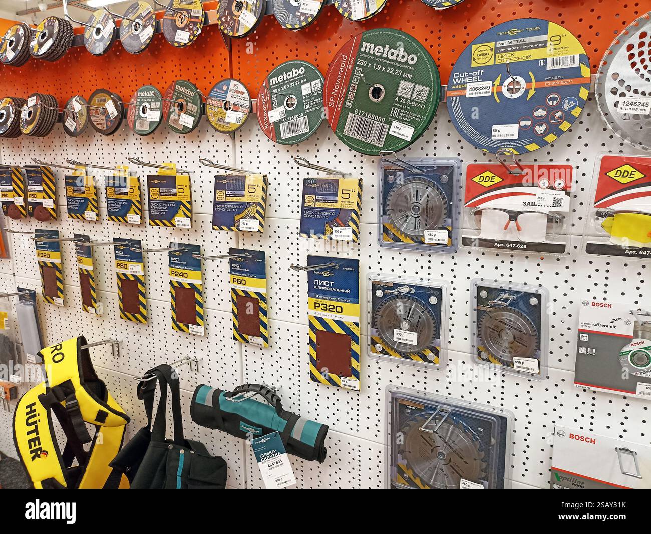 Variety of circular saw blades and sanding discs displayed on pegboard ...