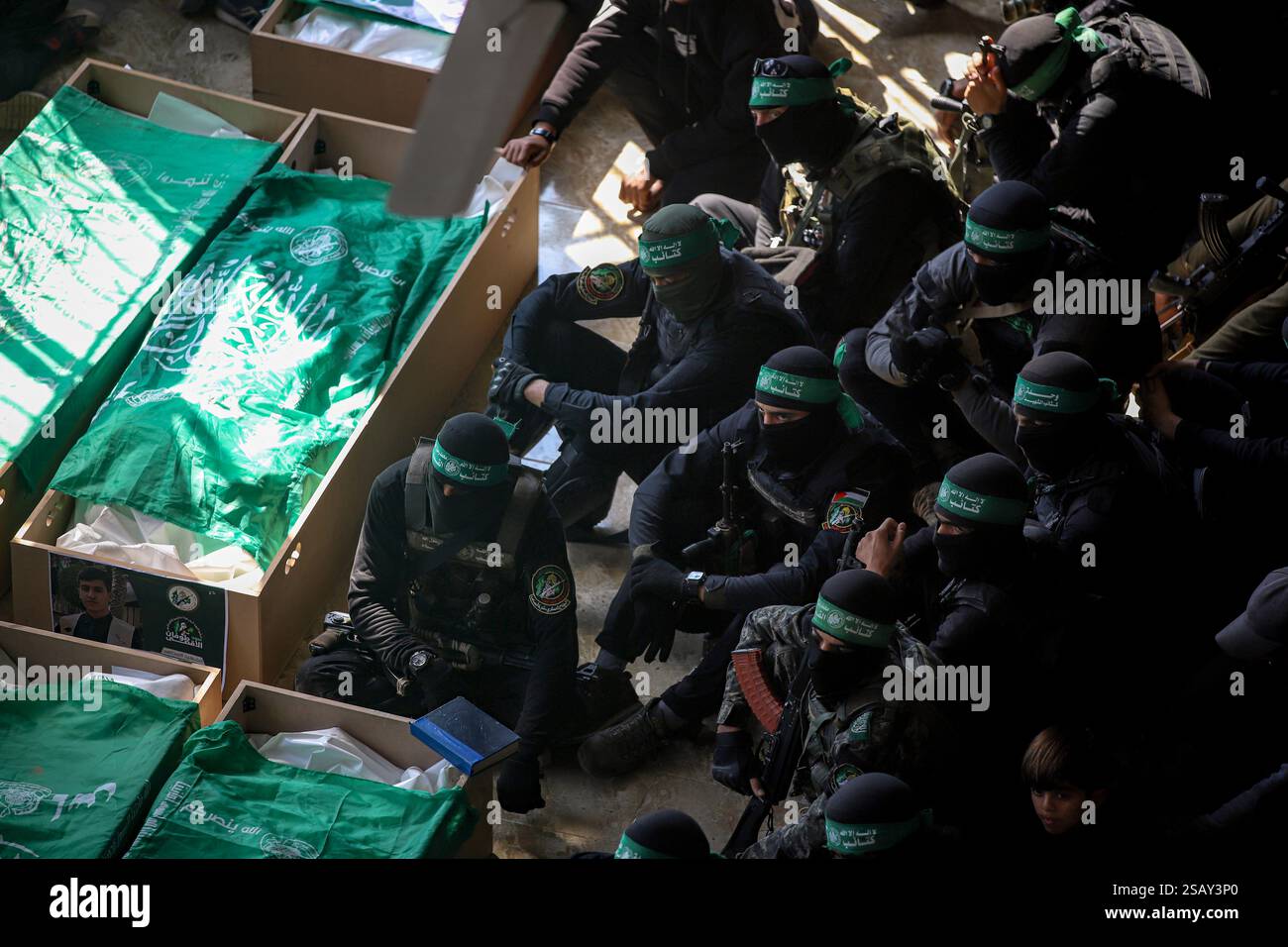 Masked militants from Hamas attend a funeral of fifteen members of ...
