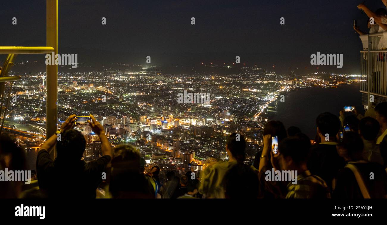 People taking pictures of a panorama of Hakodate City view from ...