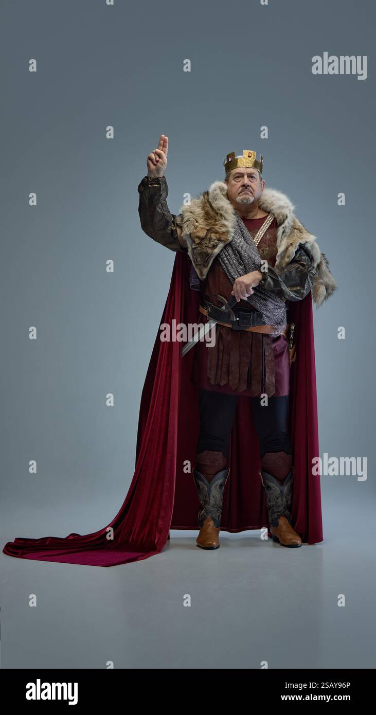 Portrait of elderly man as medieval king in red cape and fur-lined ...