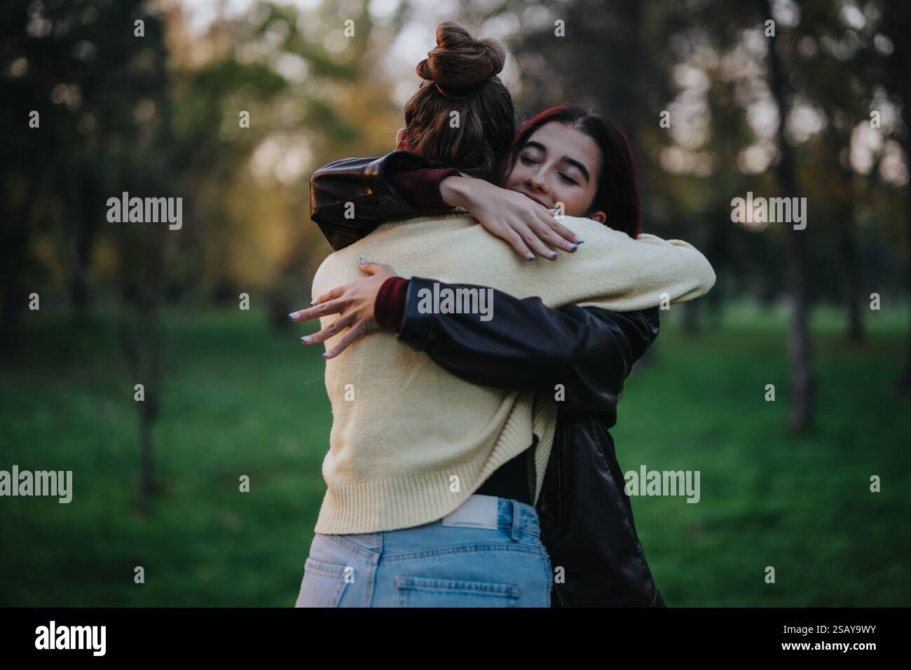 Two friends joyfully hugging in an outdoor nature park setting Stock ...