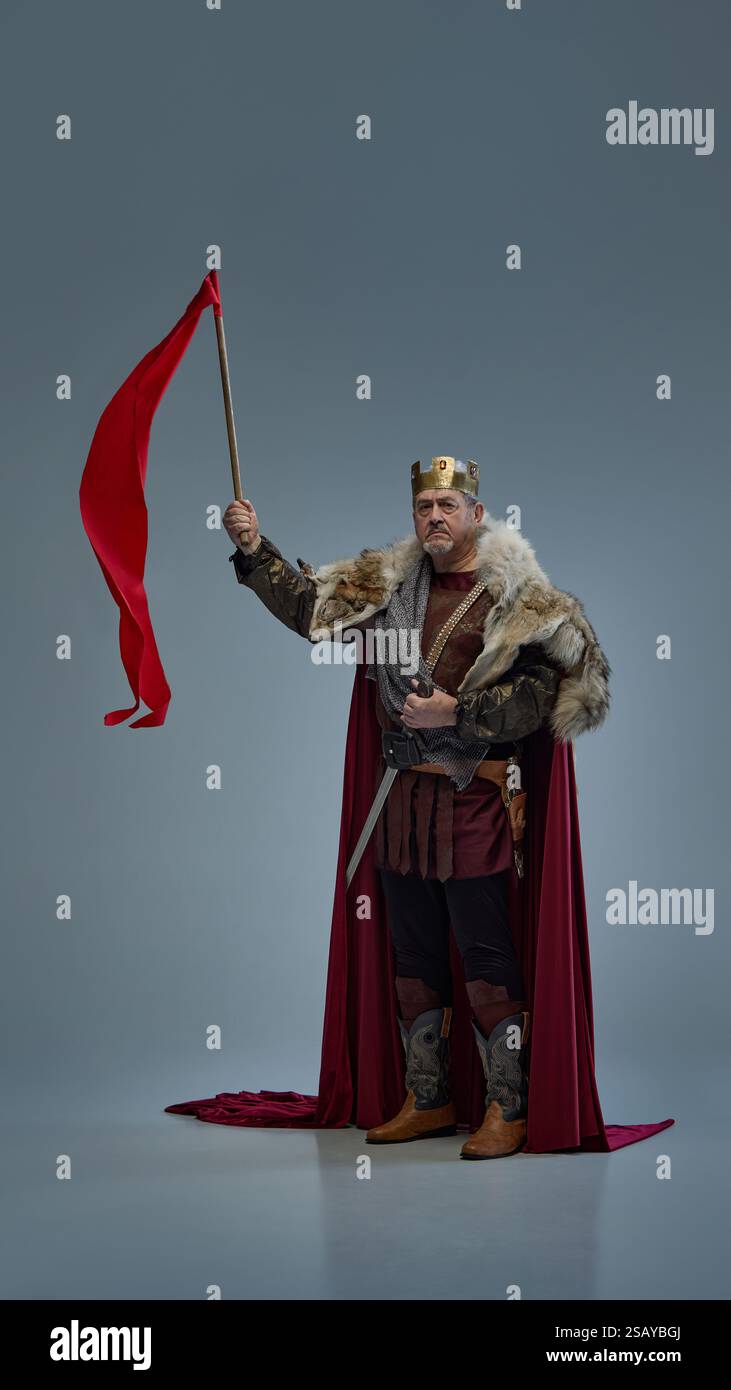Powerful medieval king holding red flag, standing with determination ...