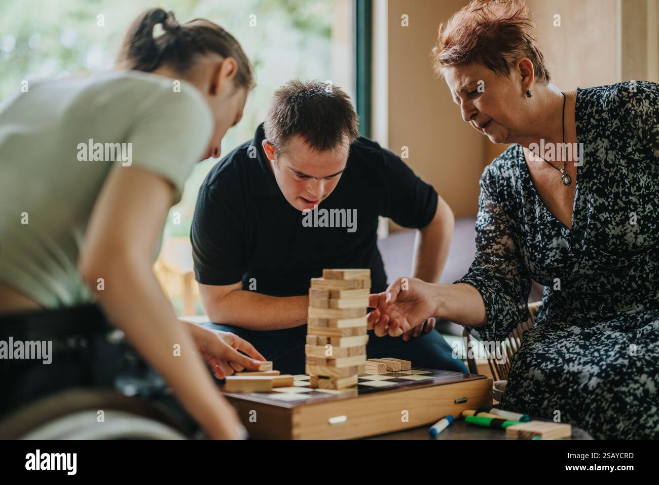 Boy with Down syndrome and friends playing building blocks together ...