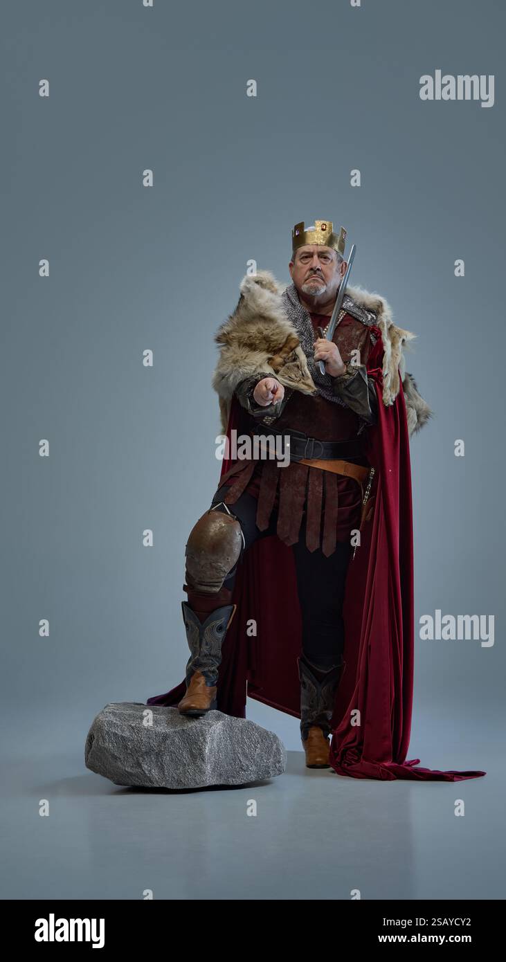 Choice. Full-length portrait of medieval king with crown and sword ...