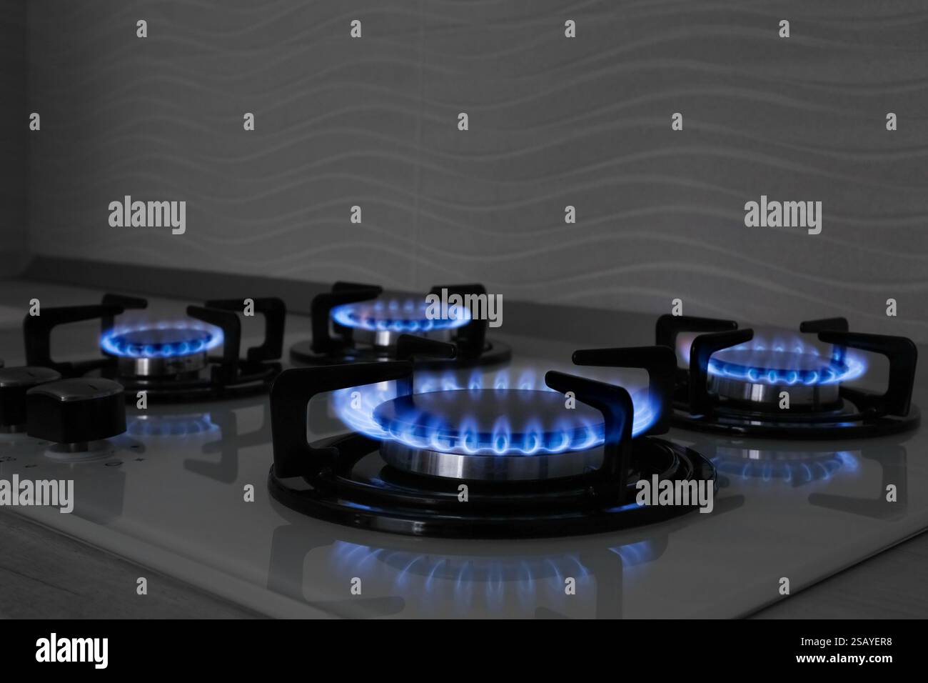 Modern gas cooktop with burning blue flames in kitchen Stock Photo - Alamy