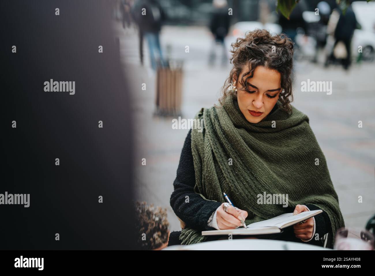 Woman Writing Outdoors With Notebook and Pen Wearing Green Scarf Stock ...