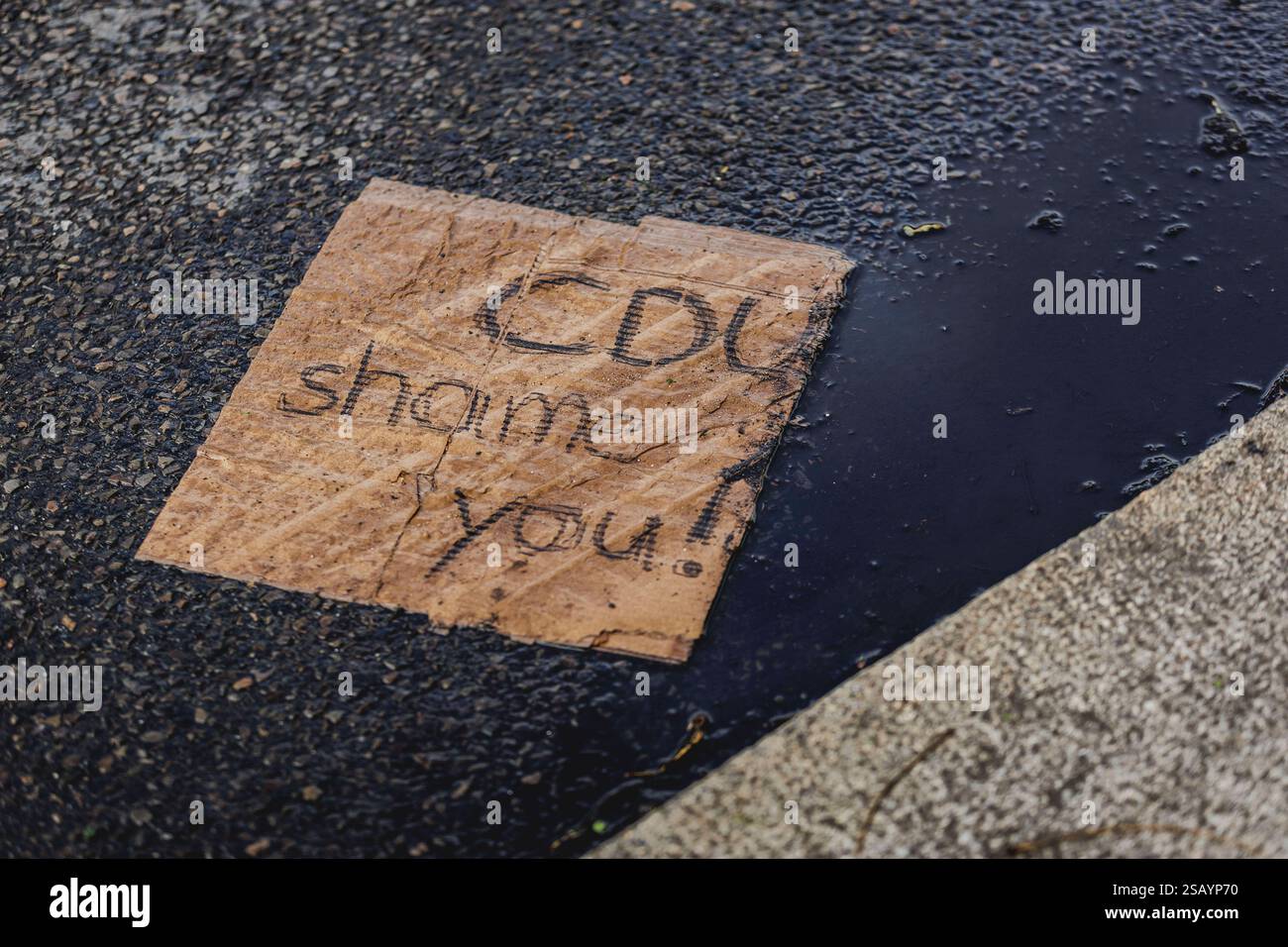 Ein kaputtes Plakat mit der Aufschrift CDU shame you liegt in einer ...