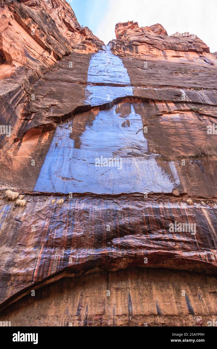 A large rock wall with a blue crack in it. The blue color of the crack ...