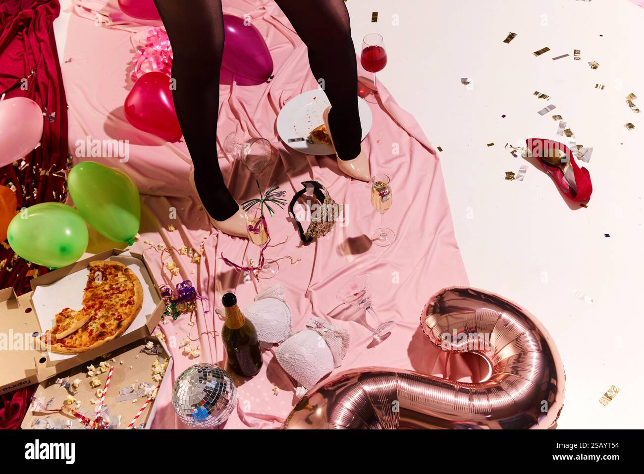 Messy afterparty floor with pink satin, green balloons, crushed ...