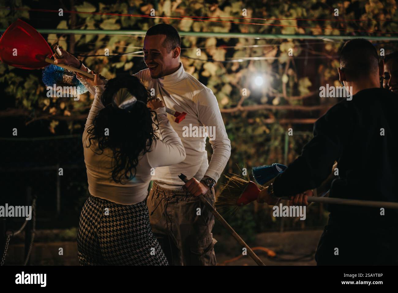 Group of friends enjoying playful fun with cleaning props during an ...