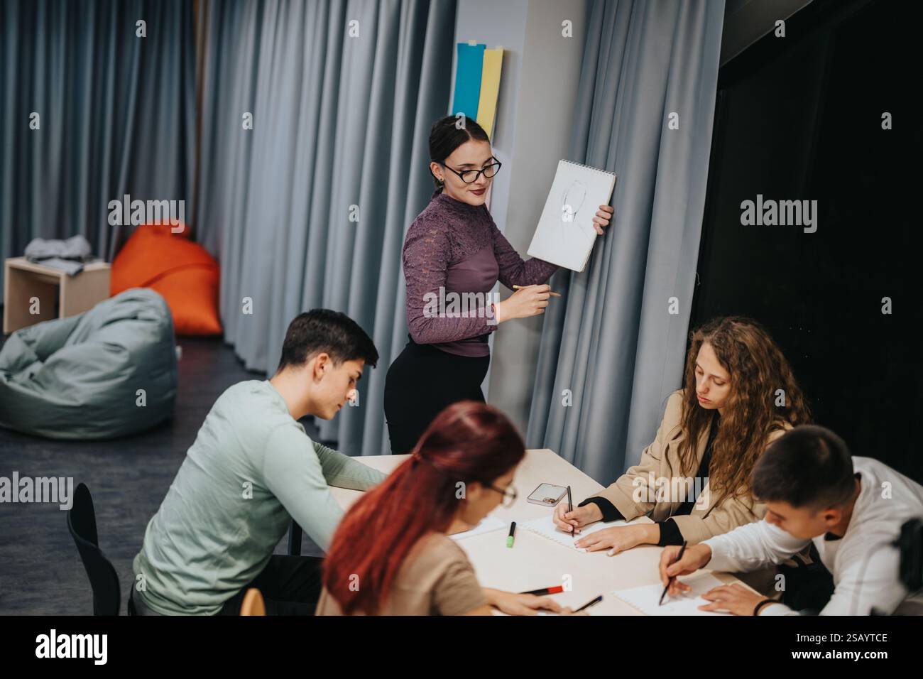 Teacher guiding students during an interactive classroom session Stock ...