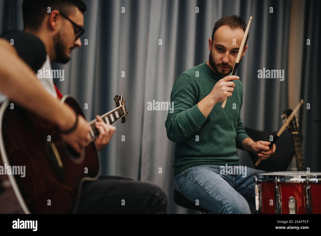 Musicians Collaborating in a Studio Playing Guitar and Drums Stock ...