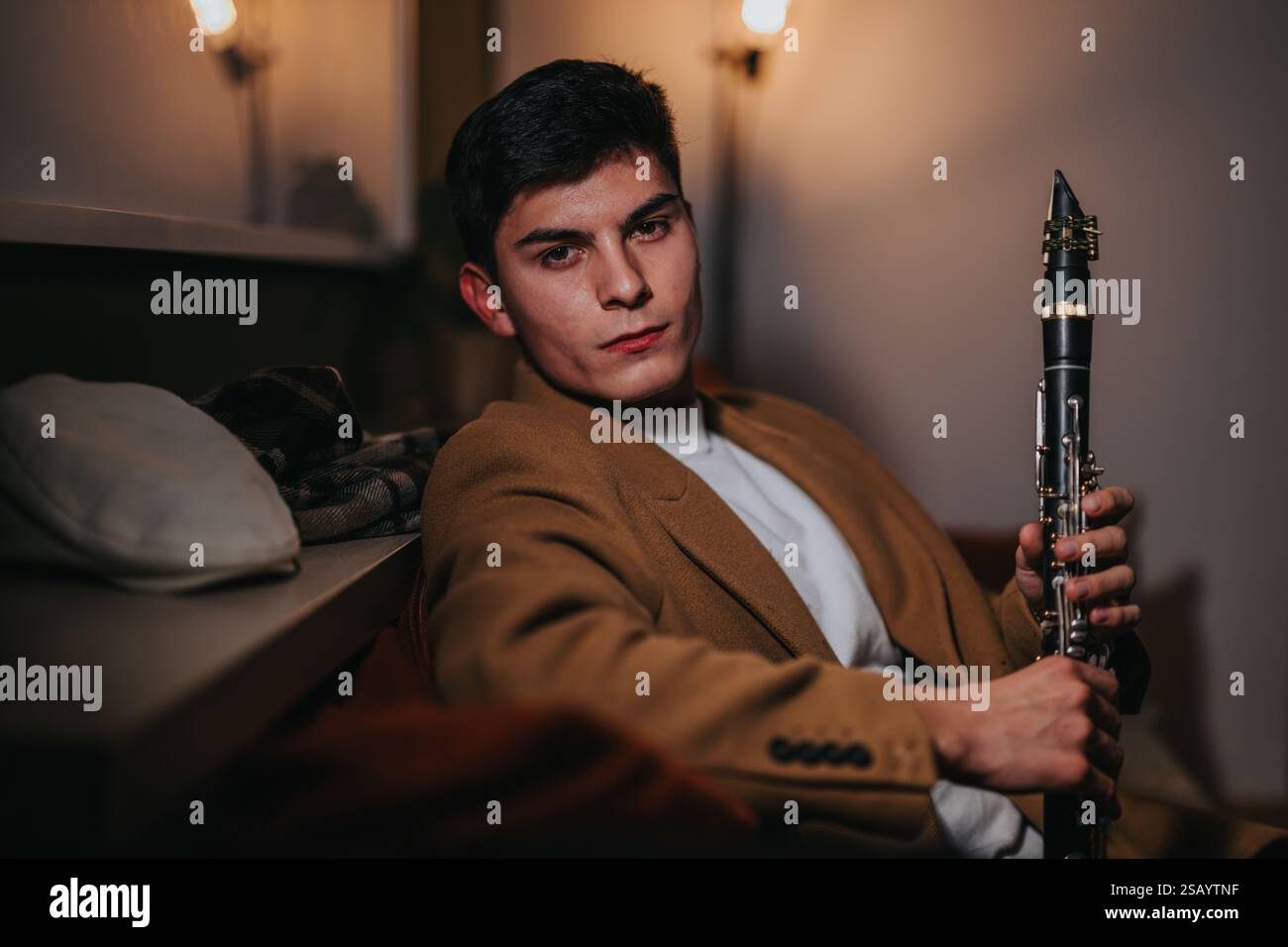 Man Posing Indoors Holding a Clarinet in a Cozy Setting Stock Photo - Alamy