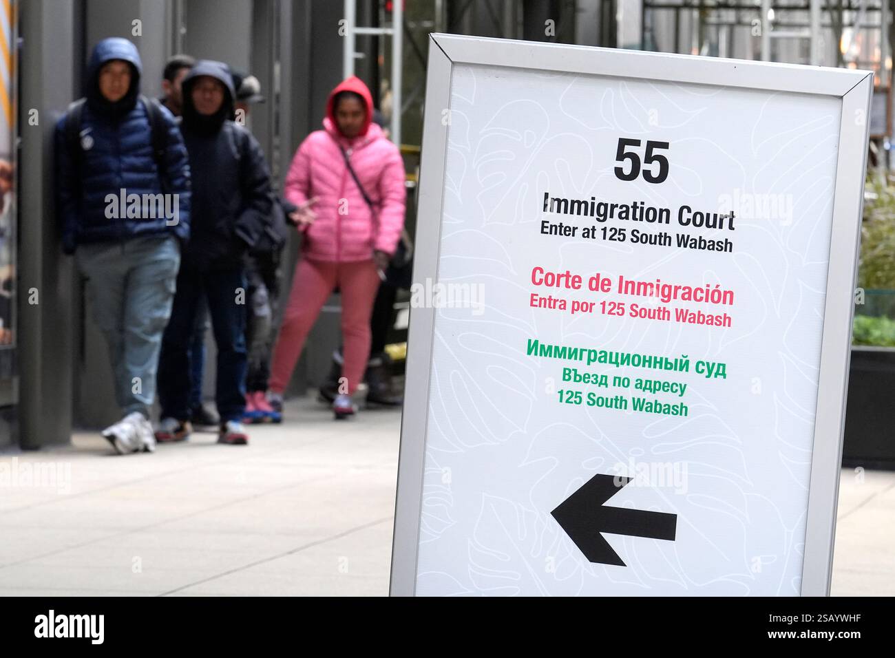 FILE - People wait in a cue before being led into a downtown Chicago ...