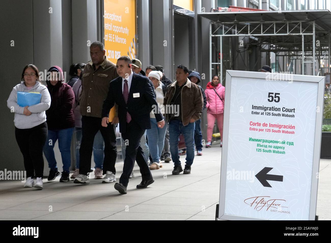FILE - After waiting in a cue, people are led into a downtown Chicago ...
