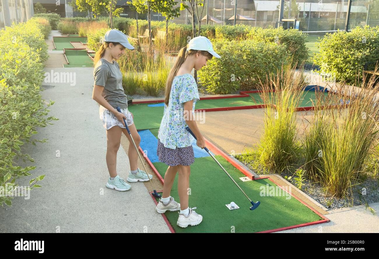 teenage girls play mini golf Stock Photo - Alamy