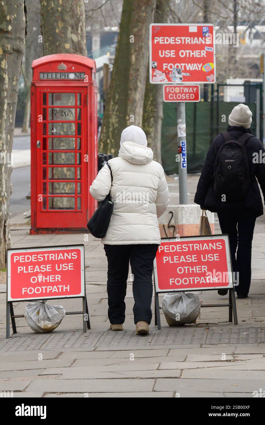 London, UK. Pedestrians ignoring signs directing them across the road ...