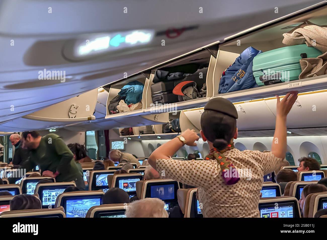 Etihad airline aircraft, interior, rows of seats with passengers ...