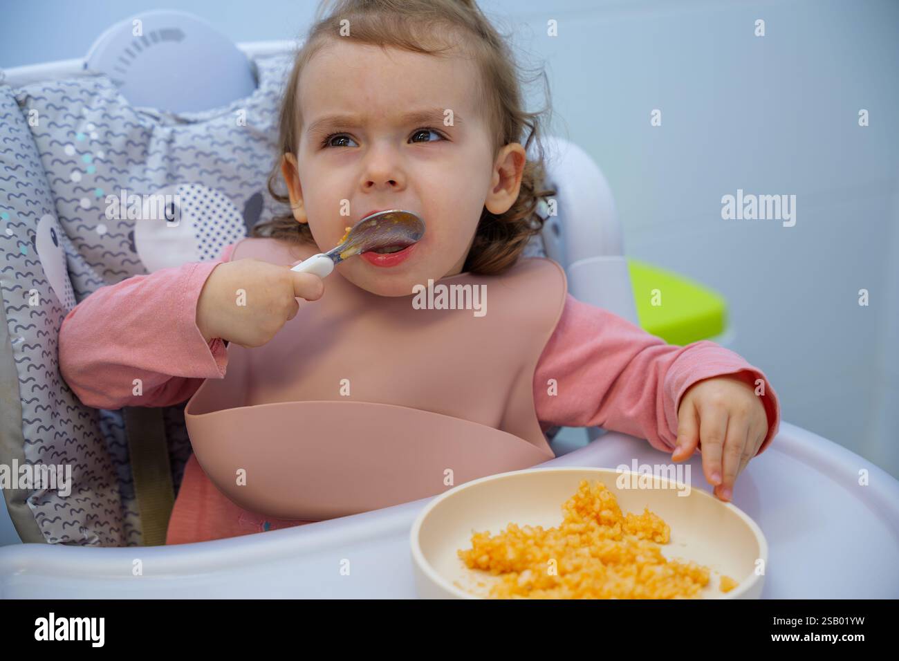 Toddler eating rice with tomato sauce, promoting healthy child ...