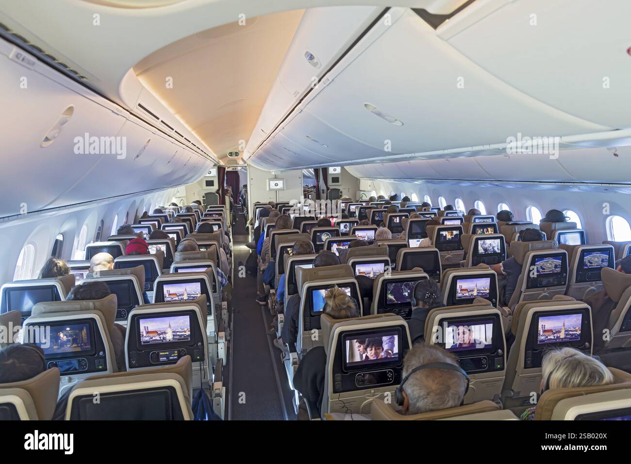 Etihad airline aircraft, interior, rows of seats with passengers ...