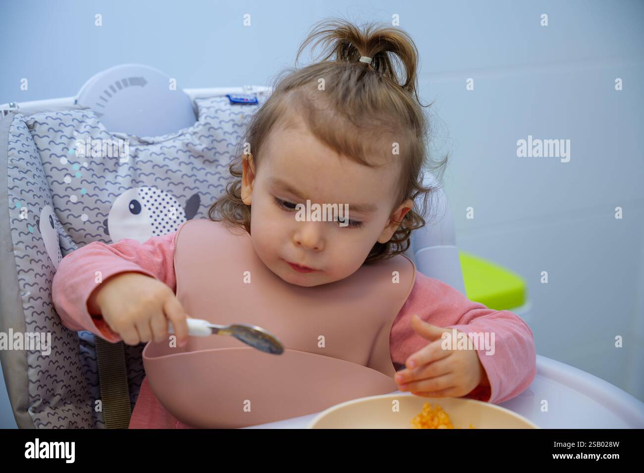 Toddler eating rice with tomato sauce, promoting healthy child ...
