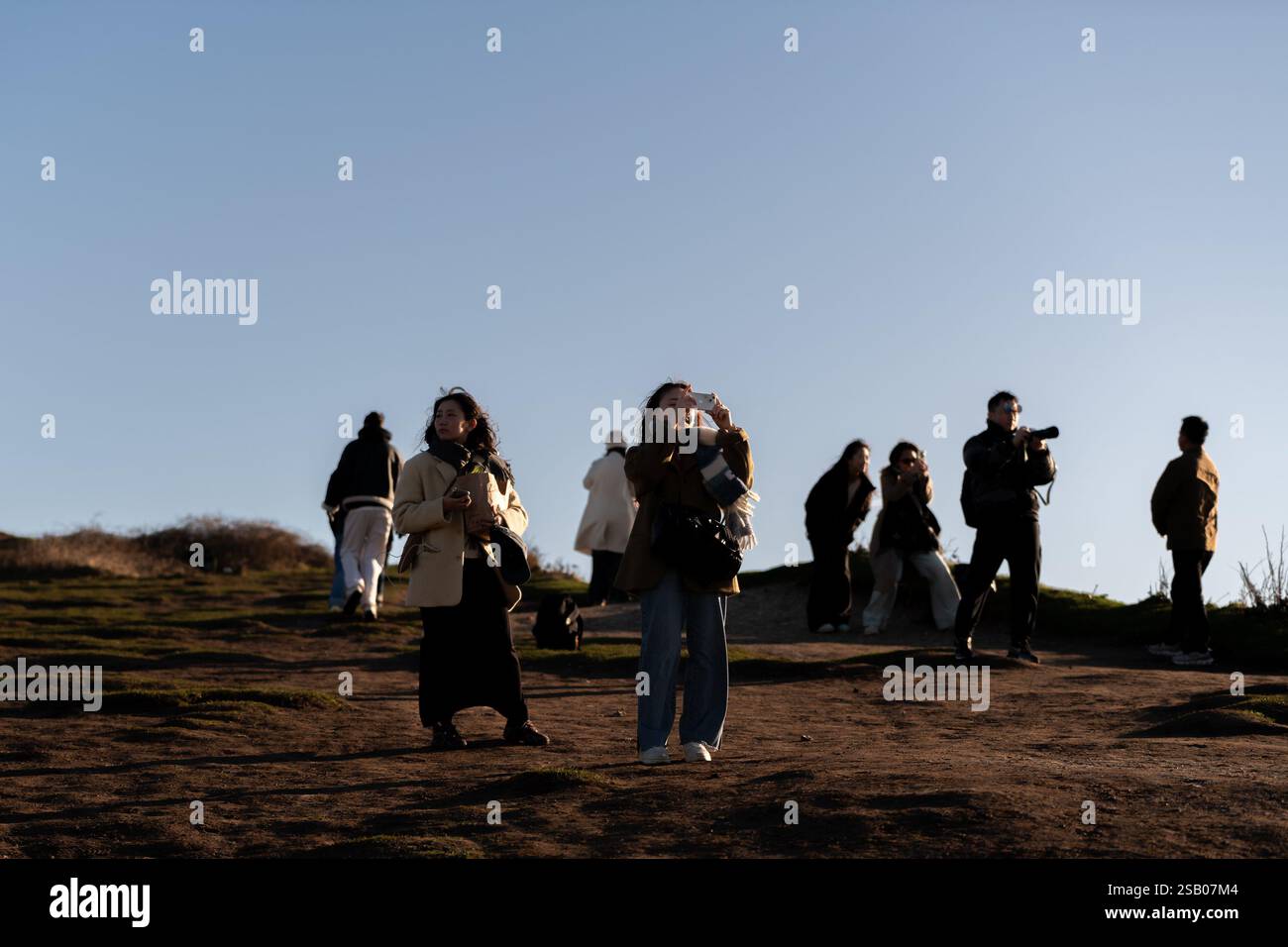 Tourists stand on the cliff edge to photograph each other and take ...