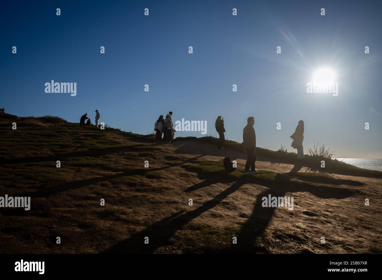 Tourists stand on the cliff edge to photograph each other and take ...