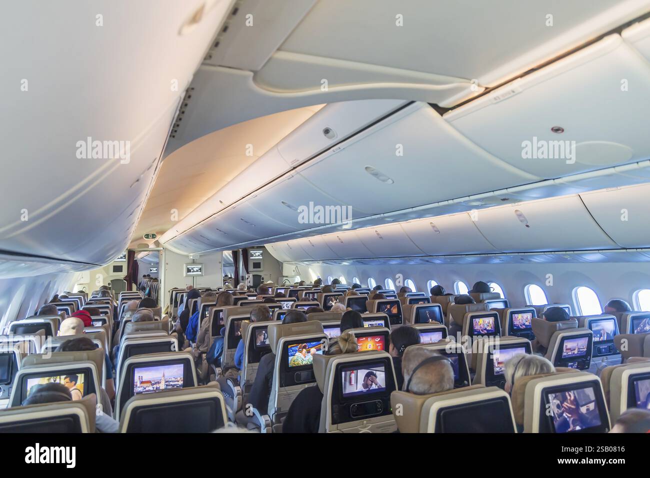 Etihad airline aircraft, interior, rows of seats with passengers ...