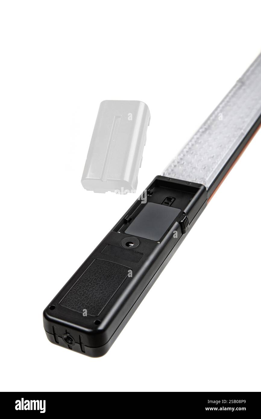 A close-up of a black handheld device with an open battery compartment ...