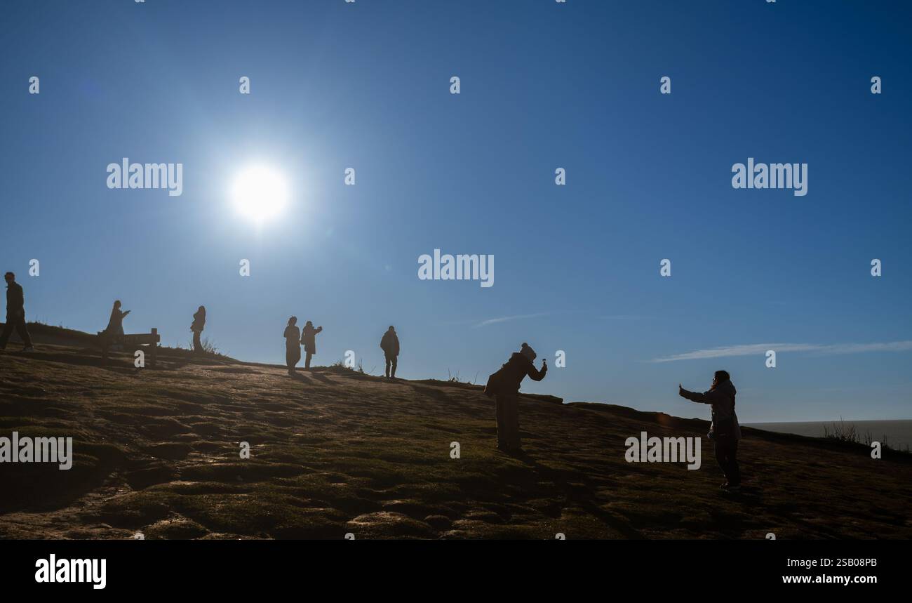 Tourists stand on the cliff edge to photograph each other and take ...