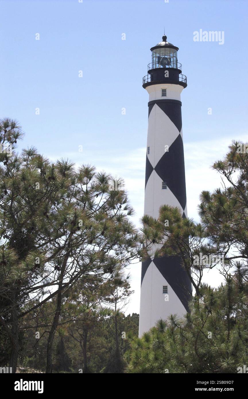 A historic lighthouse guiding ships away from rocky shoals Stock Photo ...
