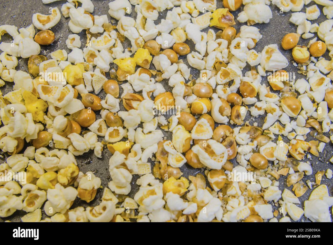 Close-up of popcorn with unpopped kernels scattered across the surface ...